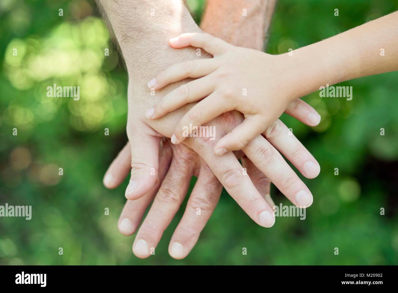 Adult and child's hands on top of each other Stock Photo - Alamy