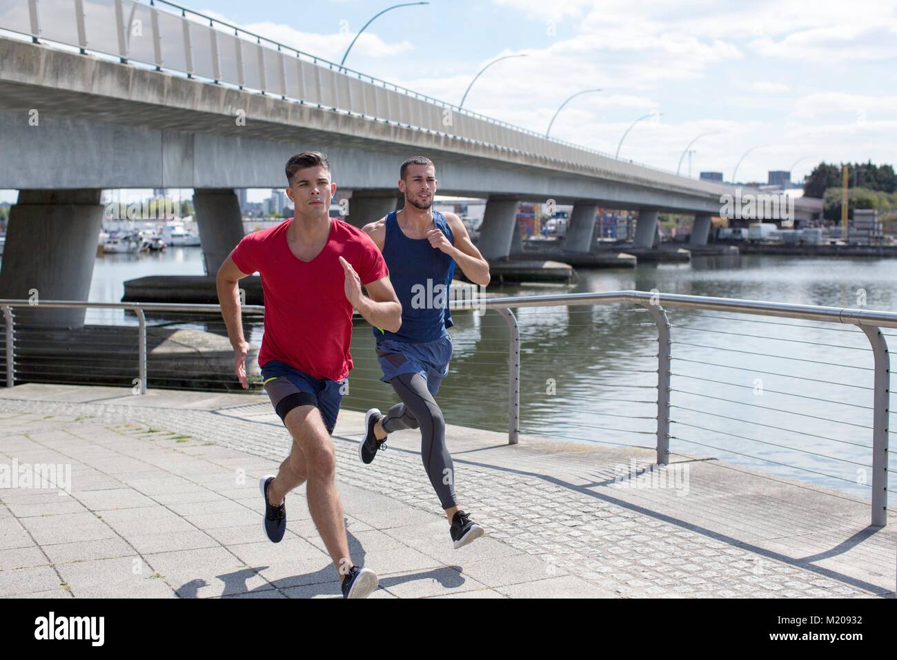 Two men running by river Stock Photo - Alamy