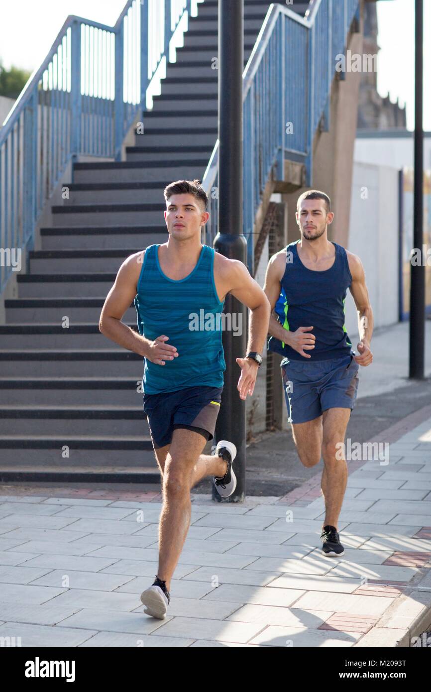 Young men running past steps Stock Photo - Alamy