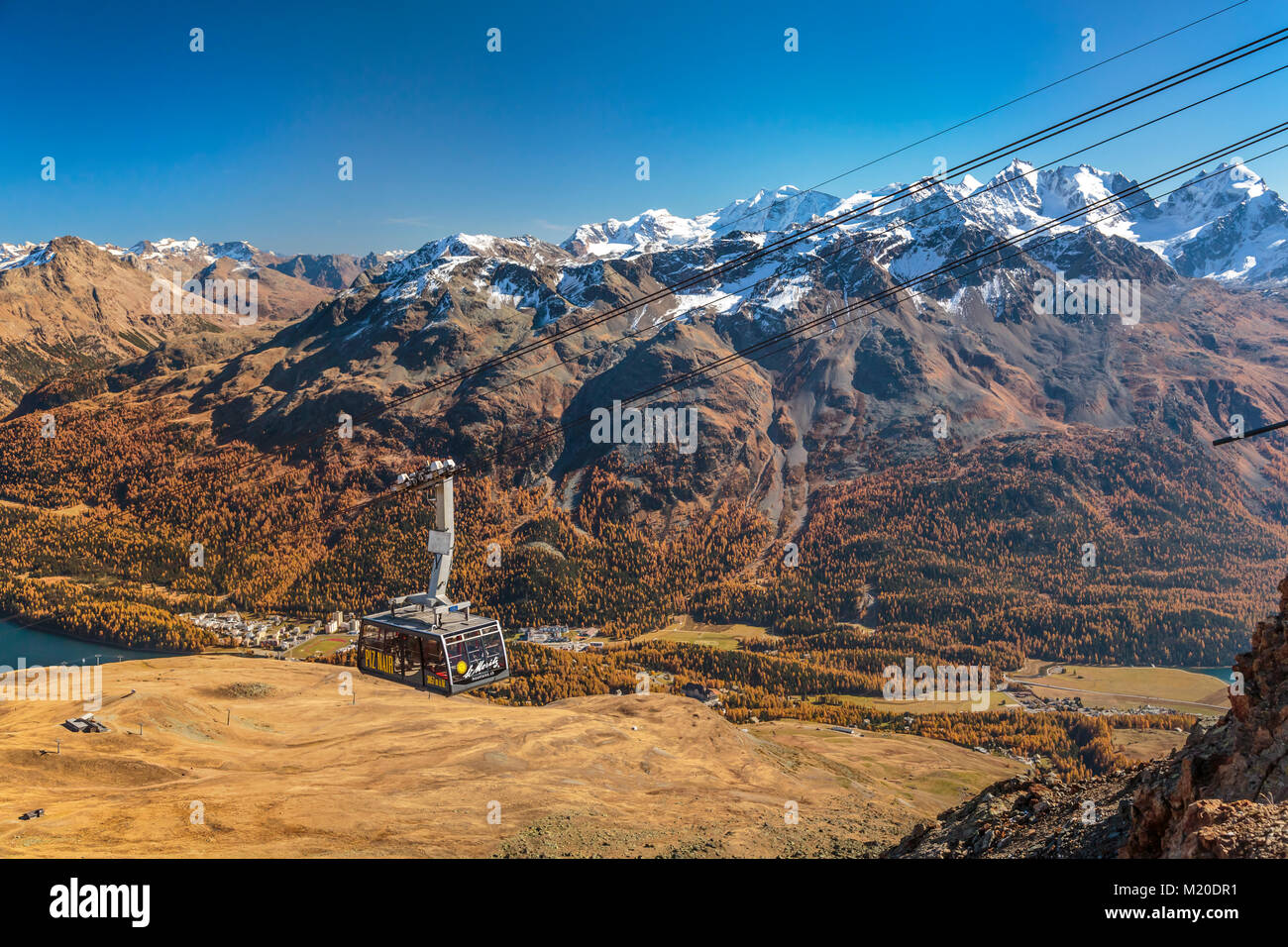 A cable car and the Piz Nair mountain range above St. Moritz ...