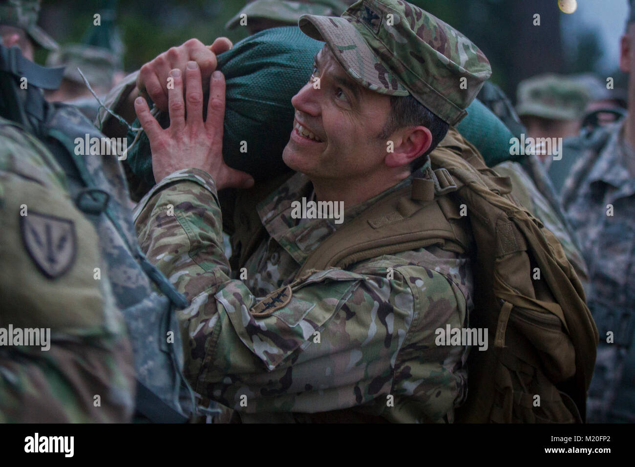 A U.S. Army Soldier, assigned to I Corps, carries a 20 pound sand bag ...