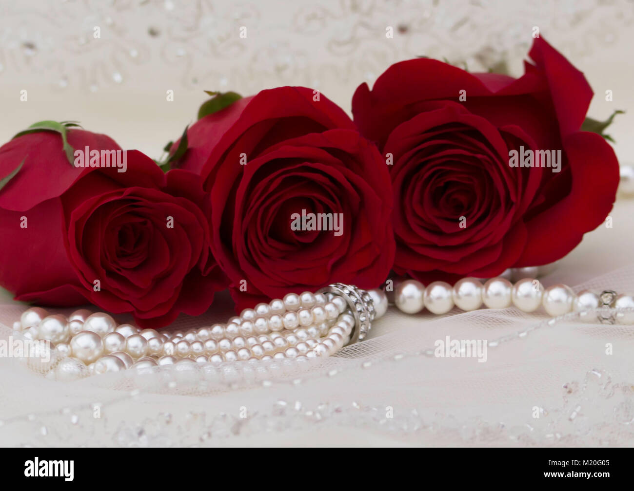 Three red roses on a wedding dress with pearls Stock Photo - Alamy