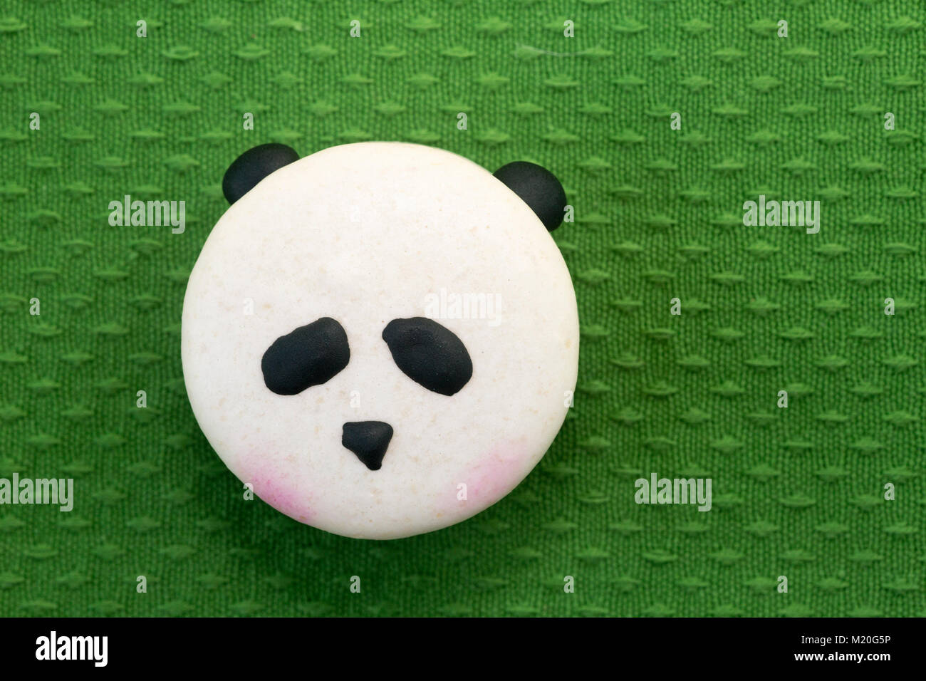 Panda macaron on a green background Stock Photo - Alamy