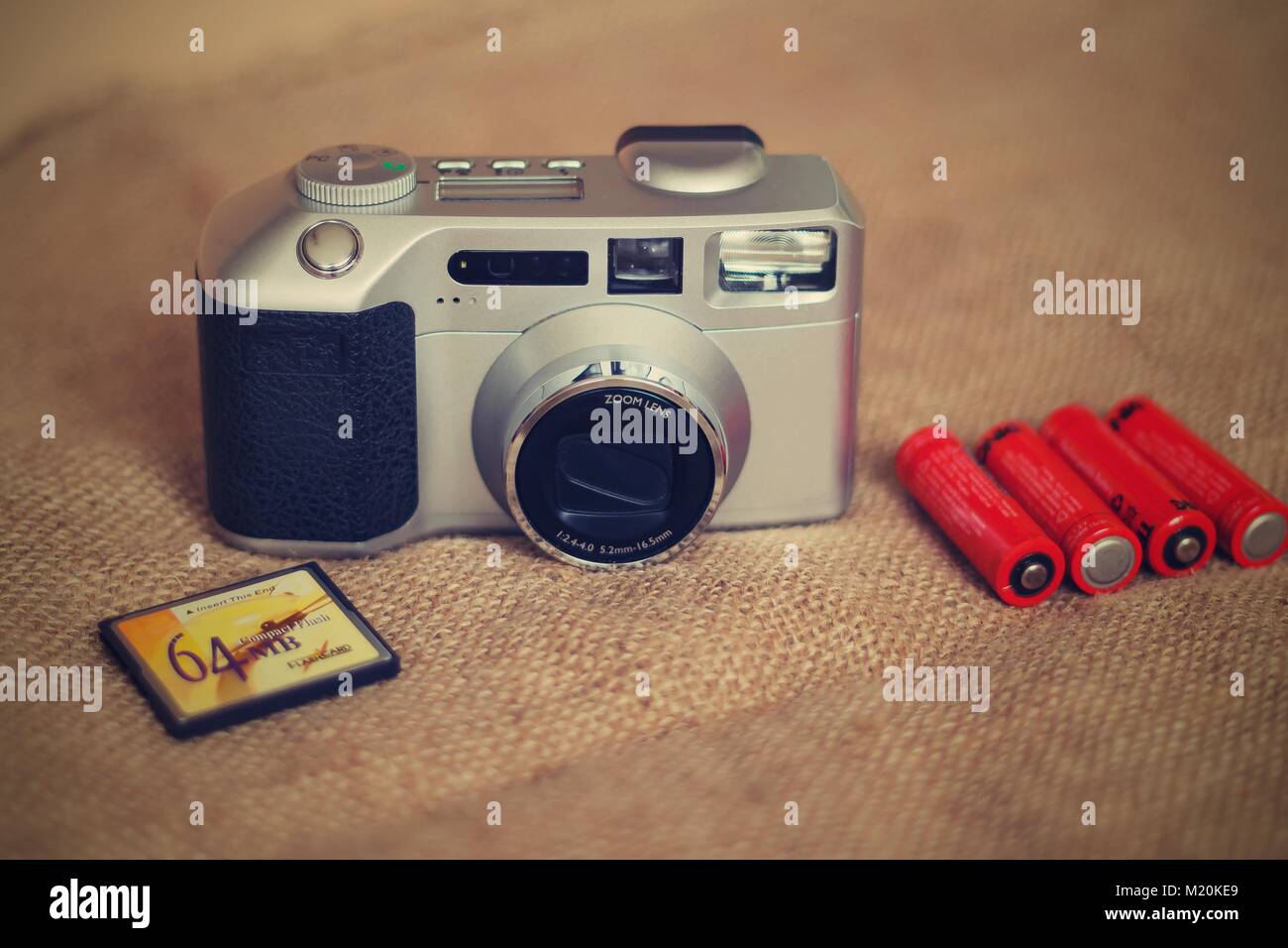 Old camera on fabric background with batteries and memory card retro ...