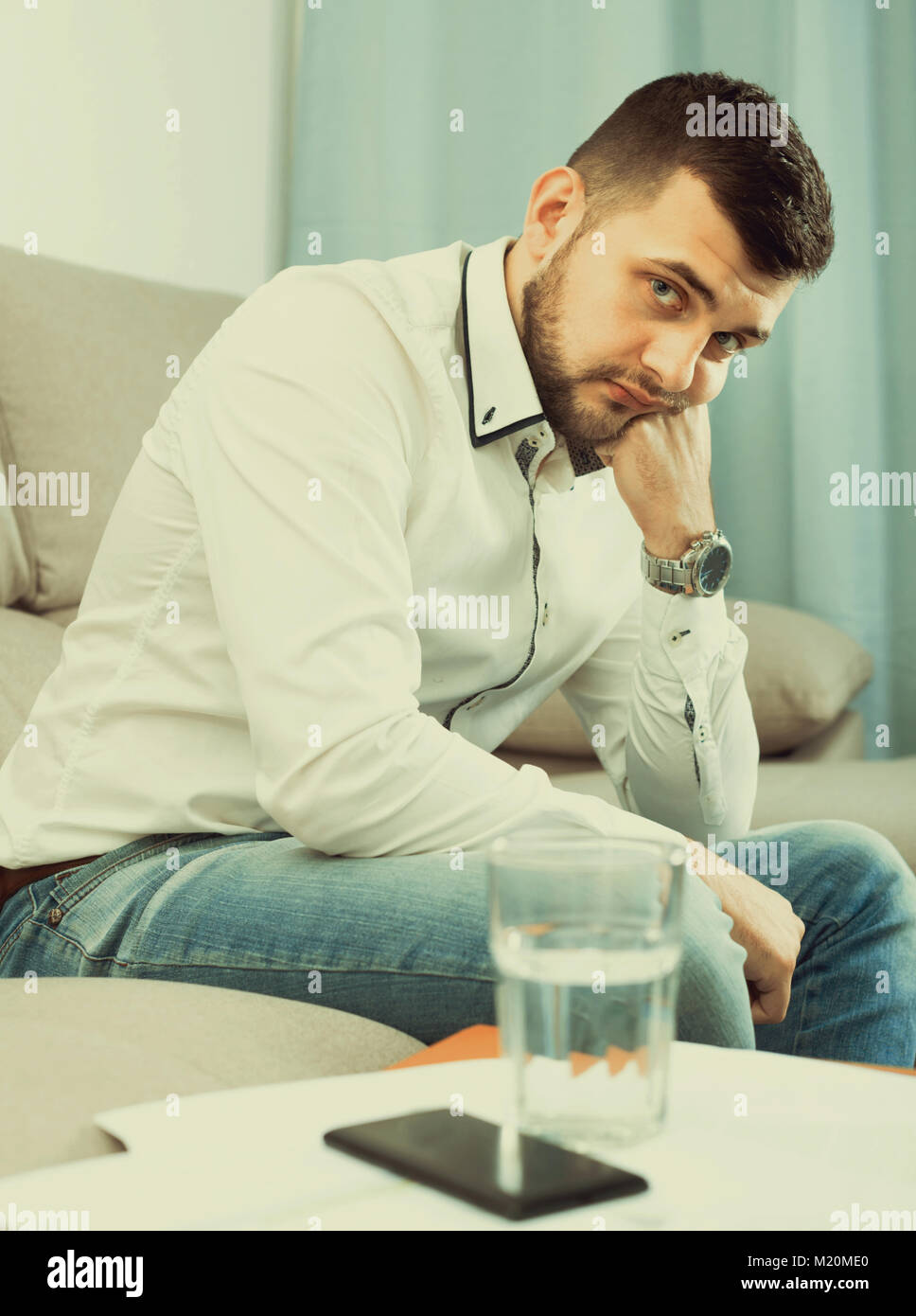 Young unhappy man feeling distressed and lonely alone at home Stock ...