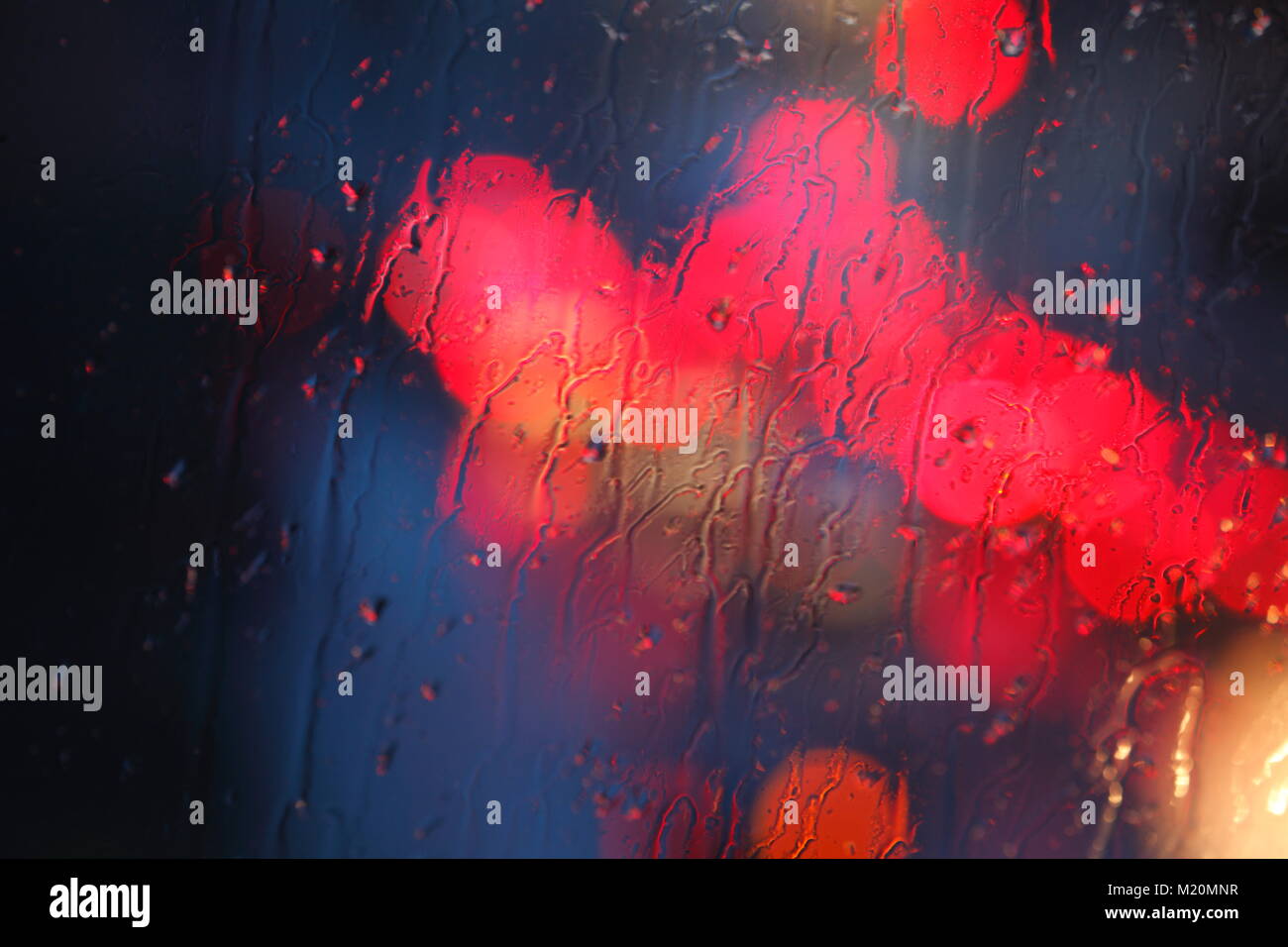 Window wet from rain, raindrops and red lights at dusk, Bremen, Germany ...