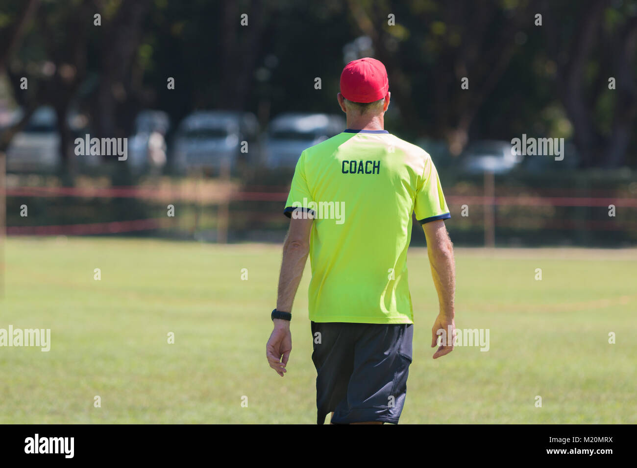 back of a coach wearing bright green color shirt with the word Coach ...