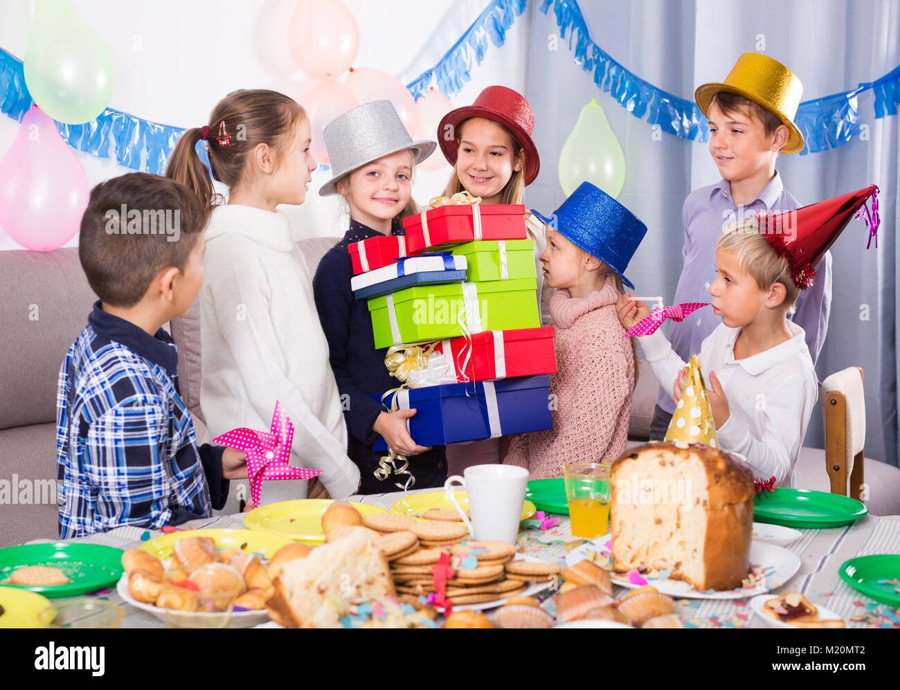 glad children giving presents to little girl during party Stock Photo ...