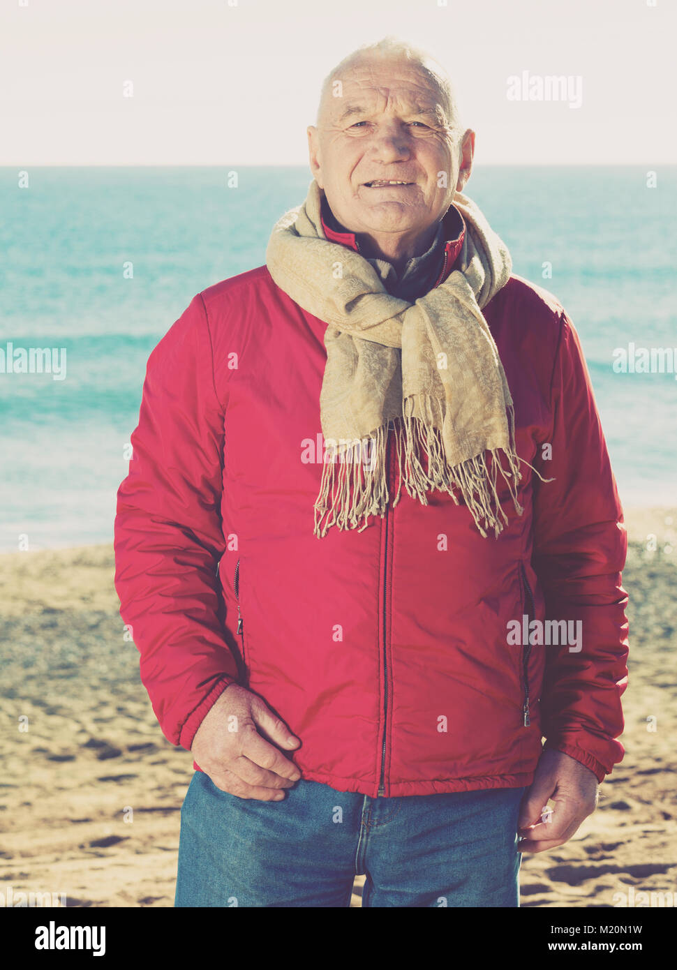 Aged man taking stroll alone on beach in cold season Stock Photo - Alamy