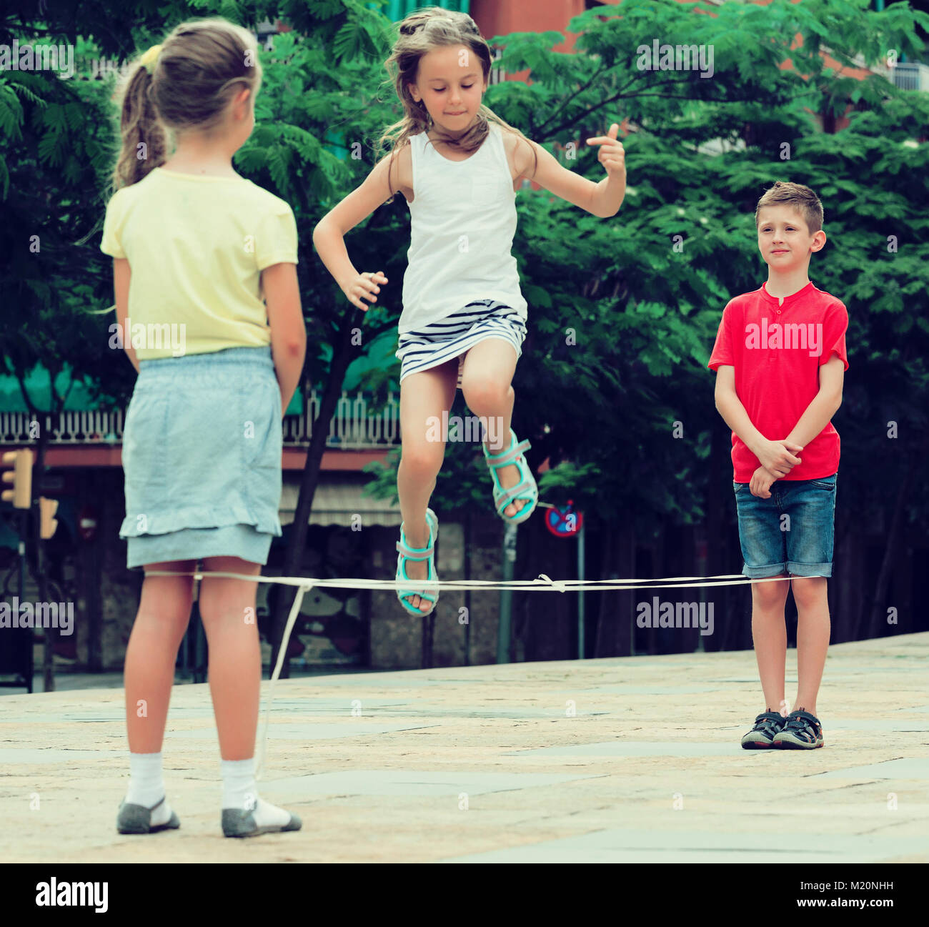 Children enjoy skipping on chinese jumping rope in urban playground in ...