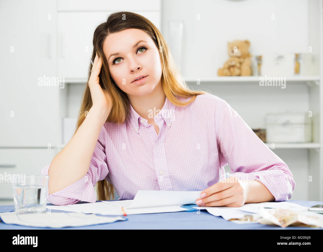 Positive girl signing agreement papers of financial nature at home ...