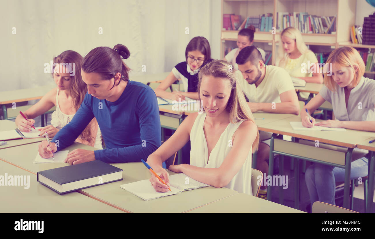 Group of university students sitting at their desks in auditorium and ...