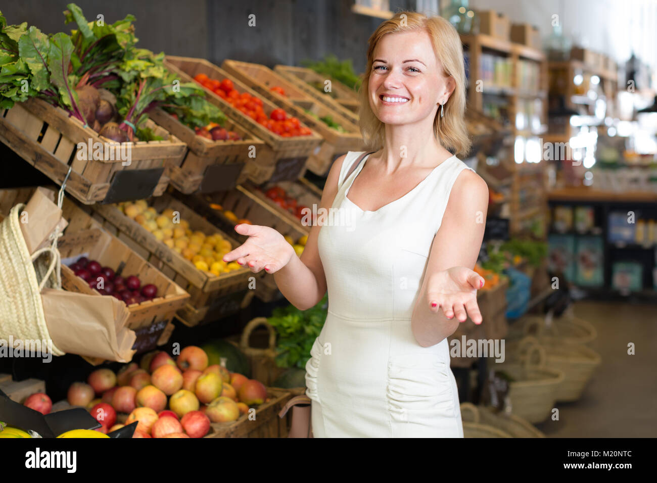 joyful female customer choosing fresh vegetables and fruits in food ...
