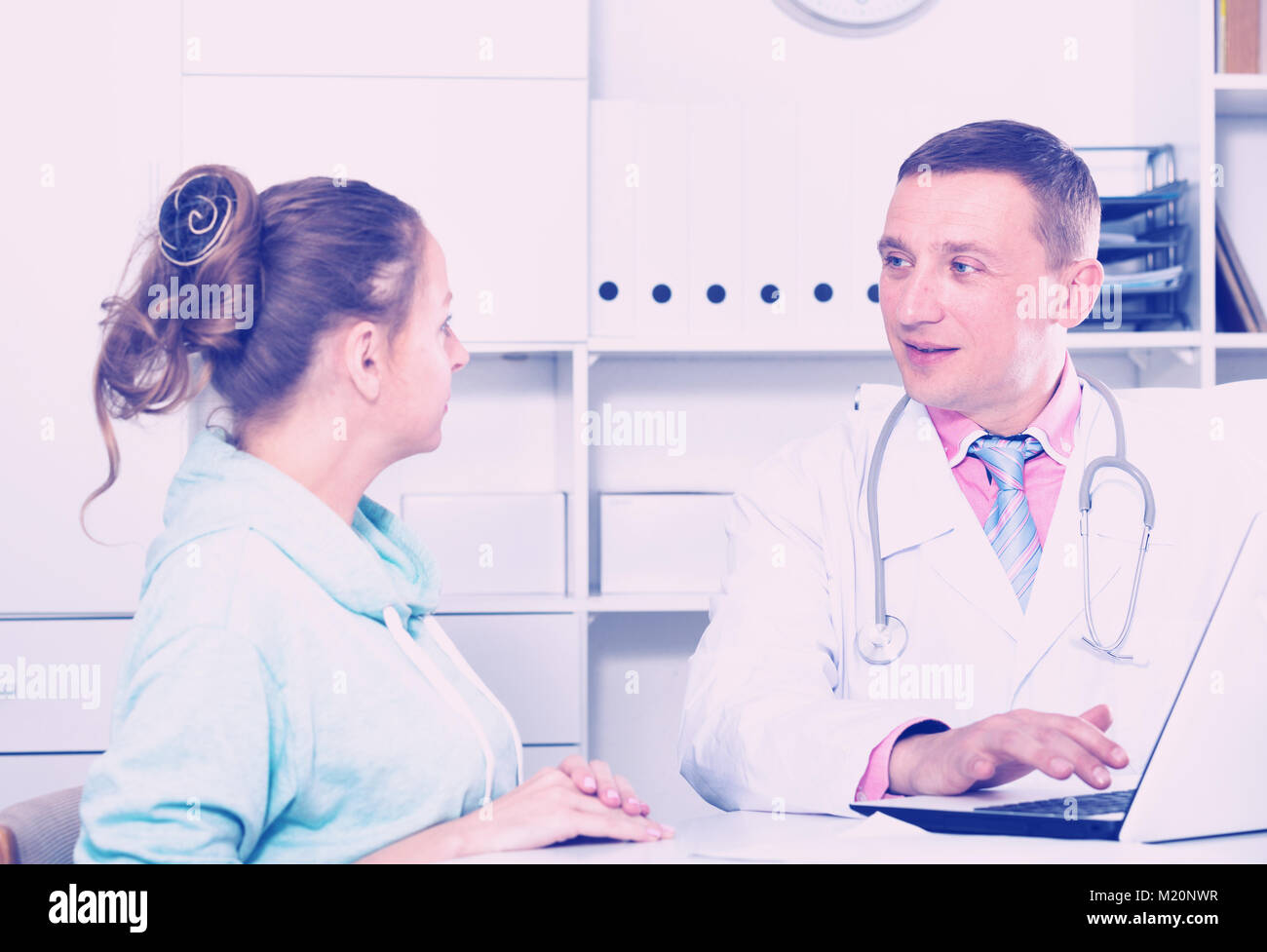 Middle-aged female client visiting consultation with man doctor in ...