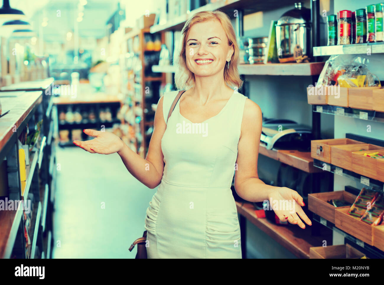 Smiling happy young woman standing among shelves in grocery store Stock ...