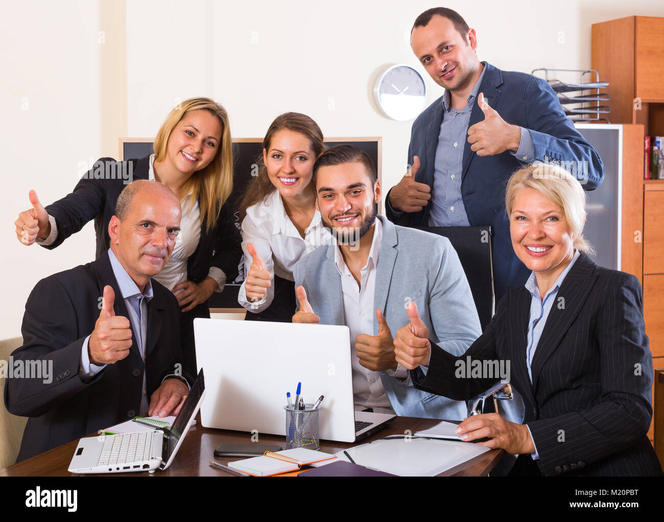 Portrait of positive colleagues at office table after successful ...