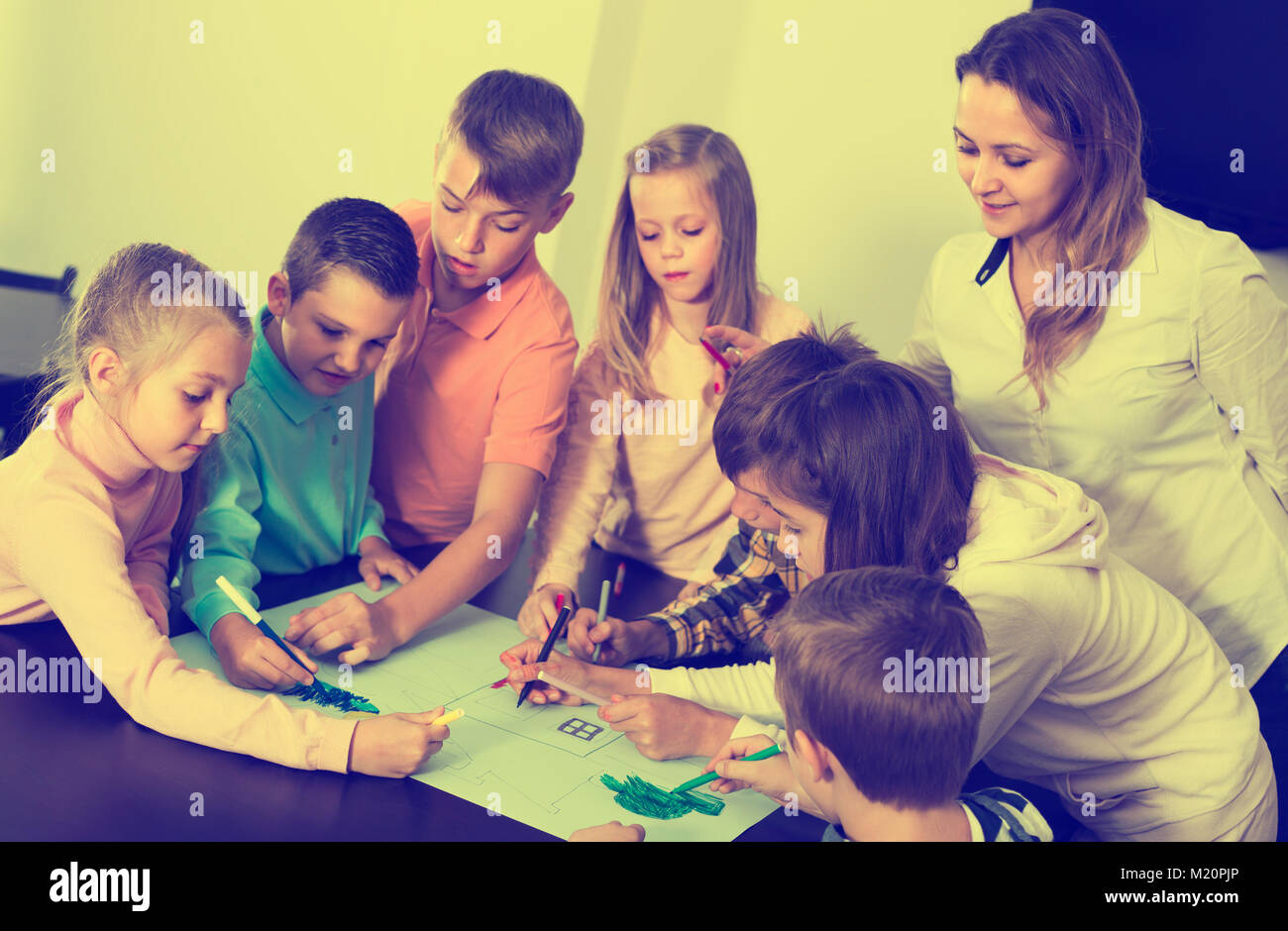 Professor and collective of elementary age children drawing together ...