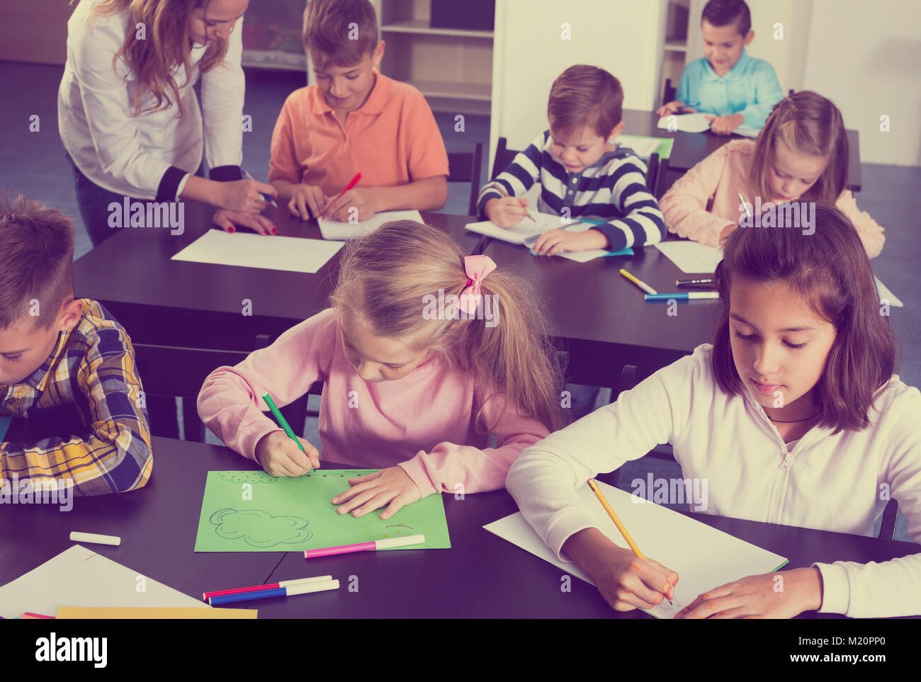 Portrait of smiling children in elementary age drawing at class Stock ...