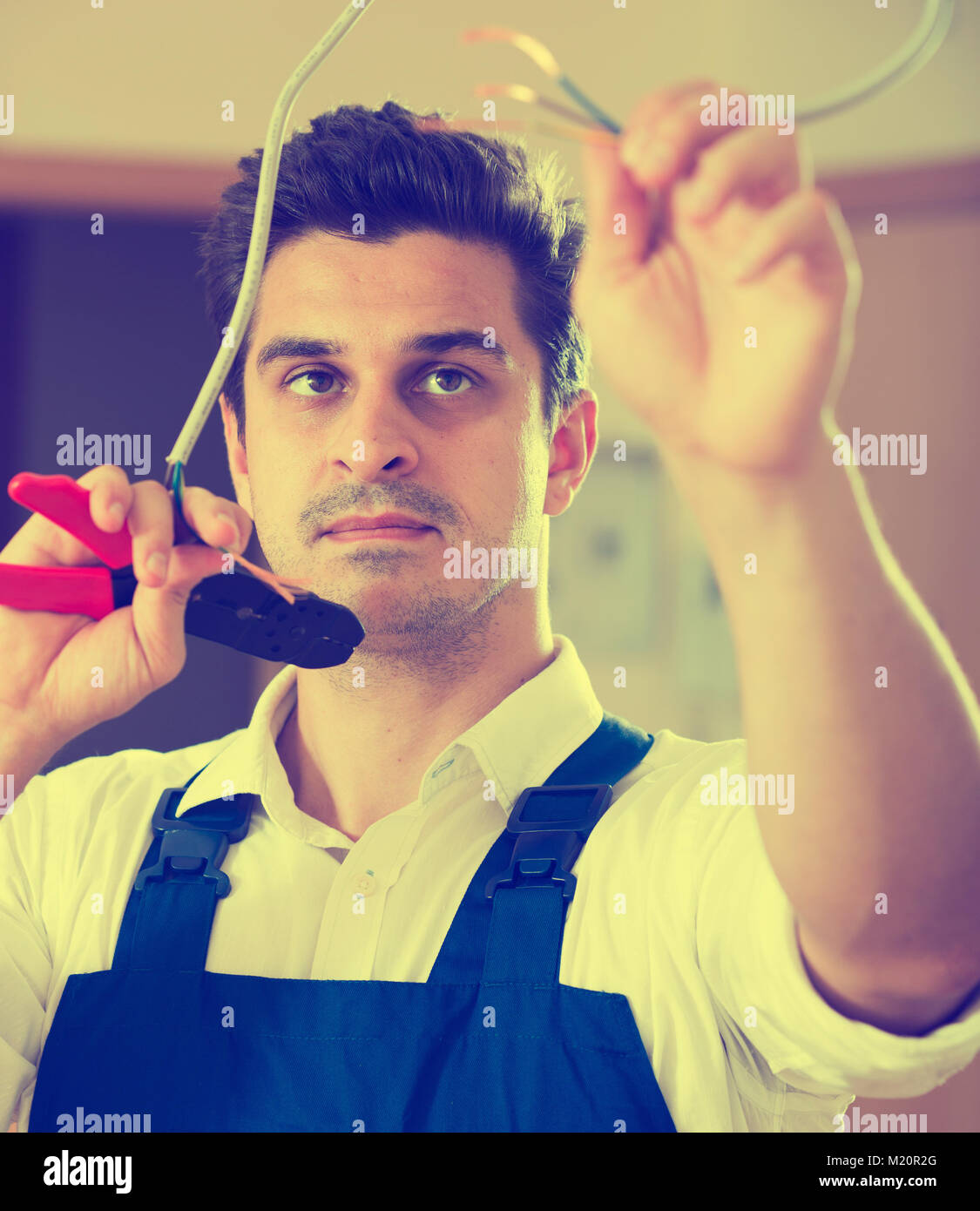 Young professional fixing indoor wiring in new building Stock Photo - Alamy