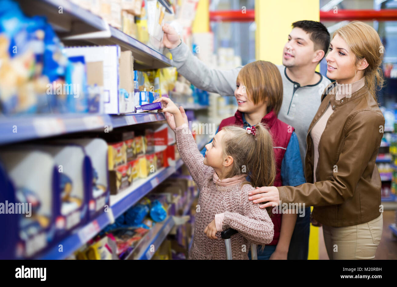happy russian parents with two kids choosing crispy flakes in shop ...