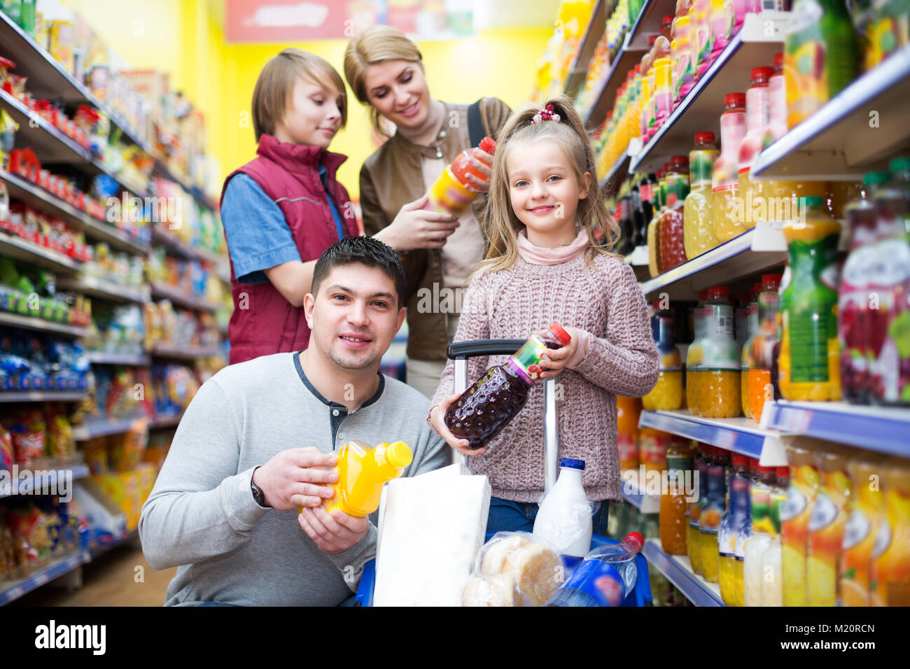 Positive family of customers with children purchasing carbonated ...