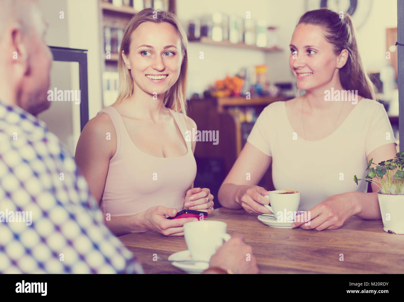 Three old friends are meeting in cafe Stock Photo - Alamy