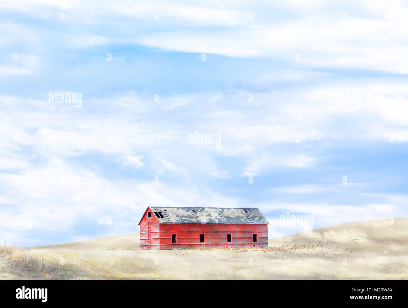 Barn on hill in cloudy field Stock Photo - Alamy