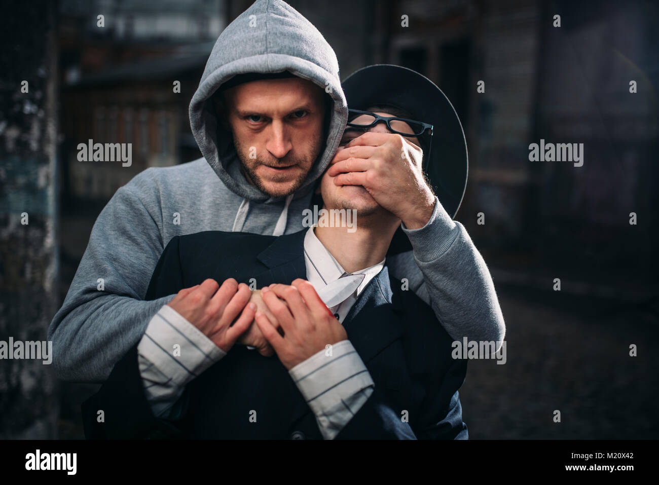 Aggressive thief with knife attack his victim on the night street ...