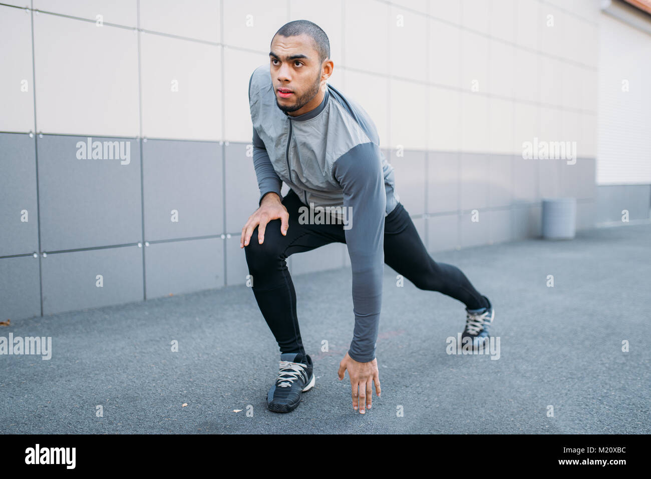 Athlete doing stretching exercise before running. Jogger on morning ...