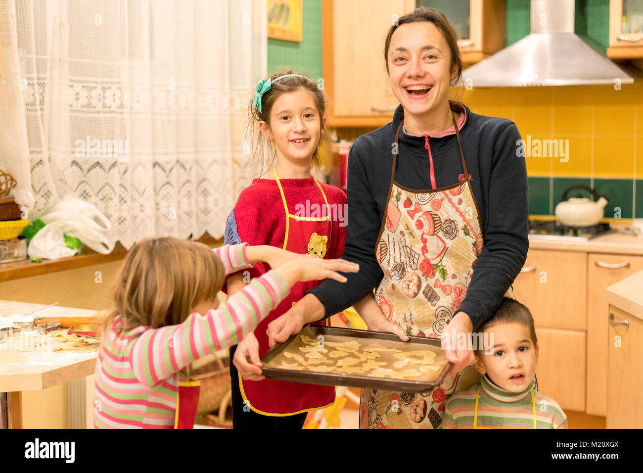 A cheerful mother with three children cooked cookies Stock Photo - Alamy