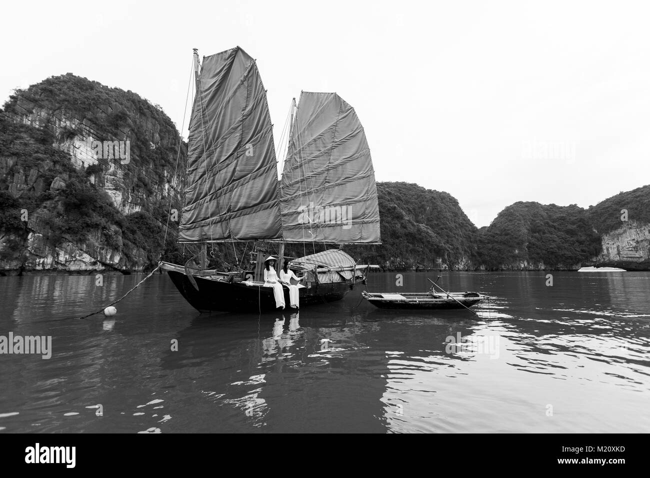 Two young Vietnamese women posing on board a sampan, a traditional ...