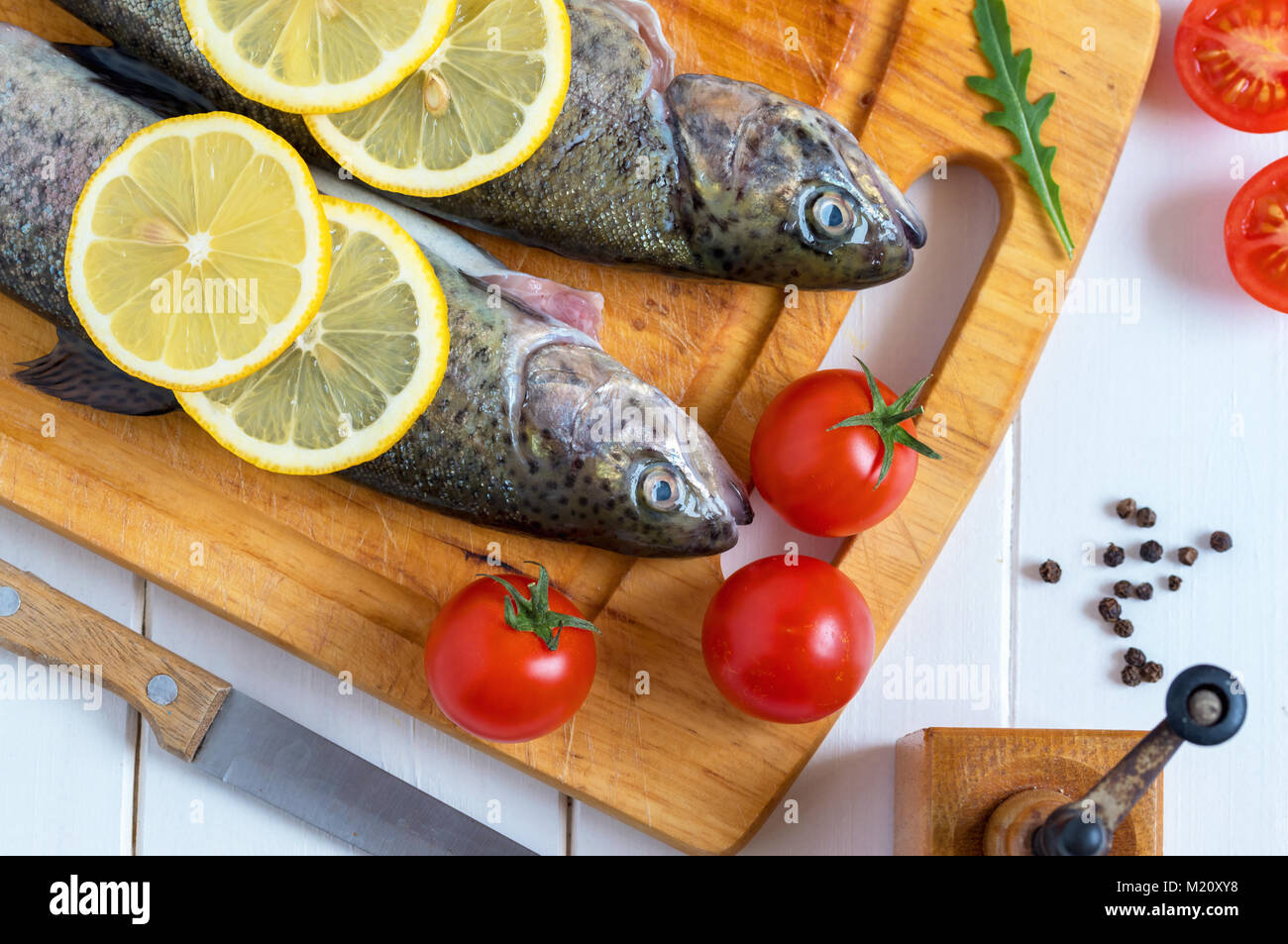 Fresh raw trout fish and food ingredients on wooden board Stock Photo ...