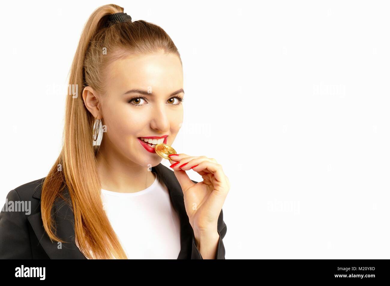 Happy caucasian woman bits a Golden Bitcoin coin Stock Photo - Alamy