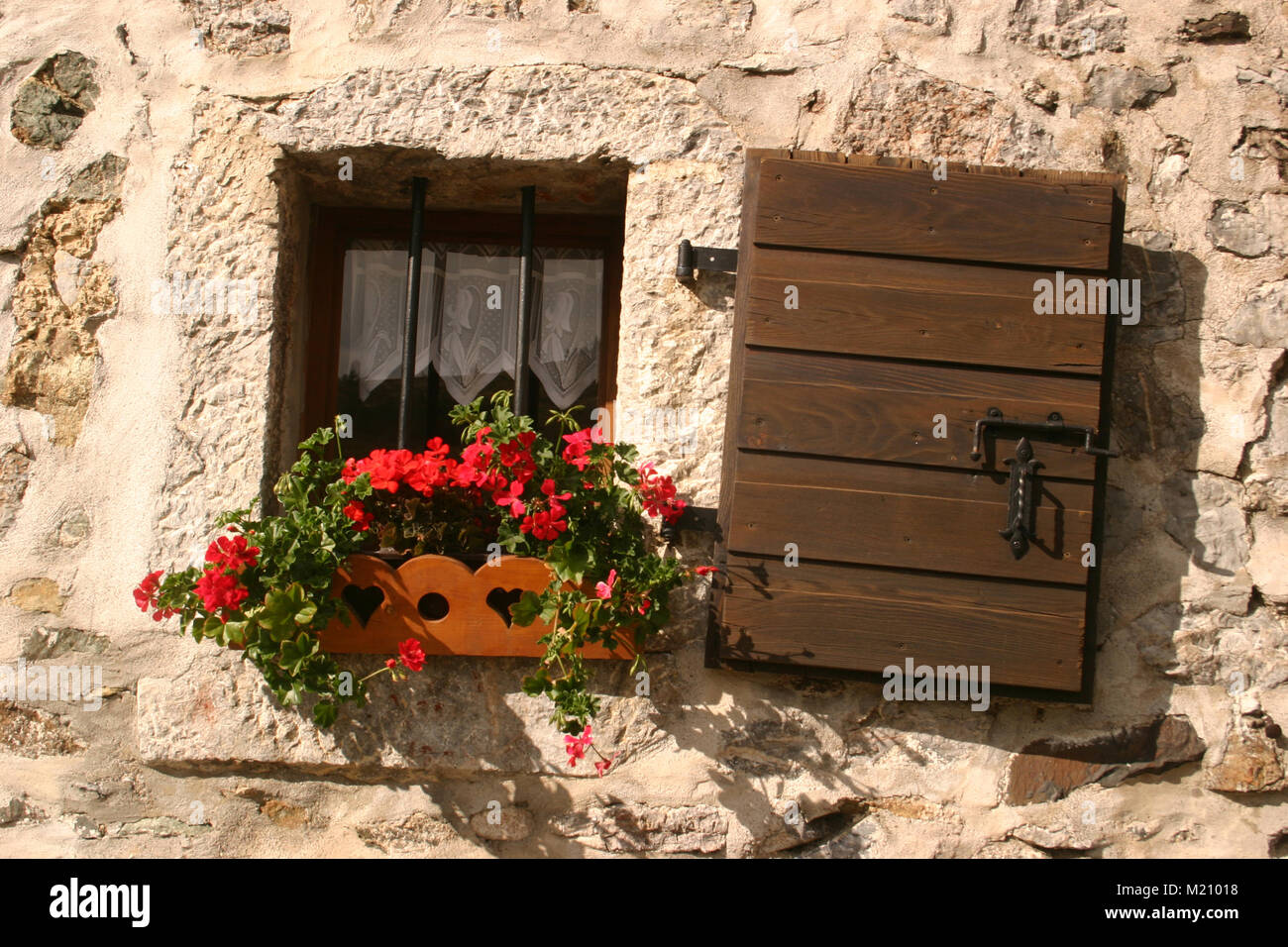 Small window decorated with geraniums in Italy Stock Photo - Alamy