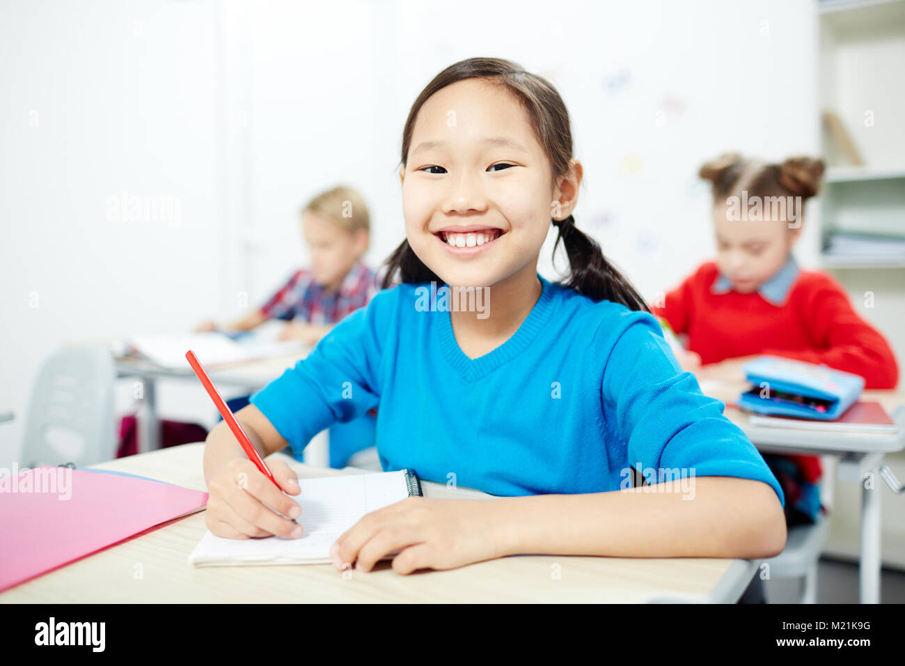Happy schoolgirl looking classmate drawing hi-res stock photography and ...
