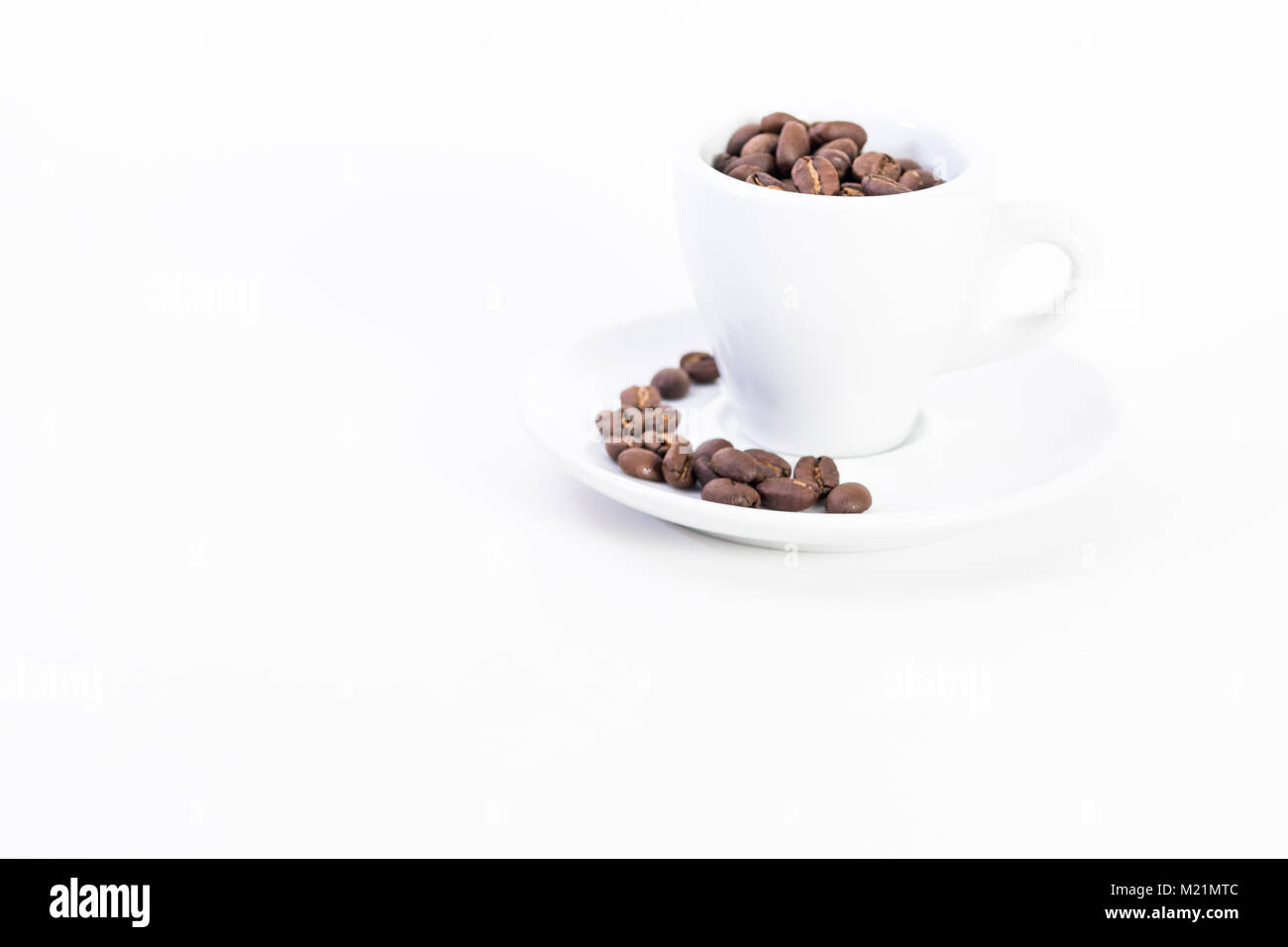 Coffee beans in a coffee or espresso cup, plain white background Stock ...