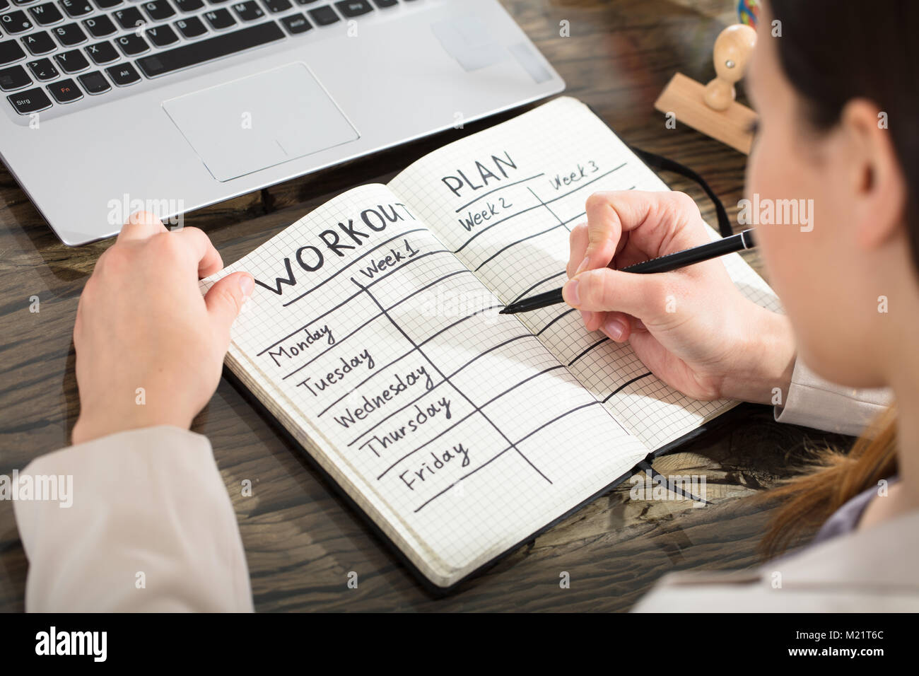 Businesswoman Writing Down A Week Plan In Her Organizer Over The Desk ...