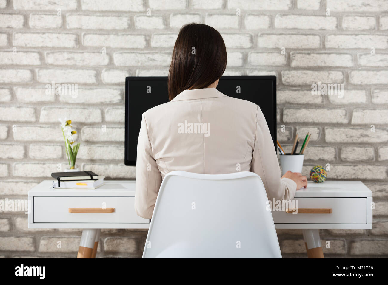 Rear View Of A Businesswoman Using Computer At Workplace In Office ...