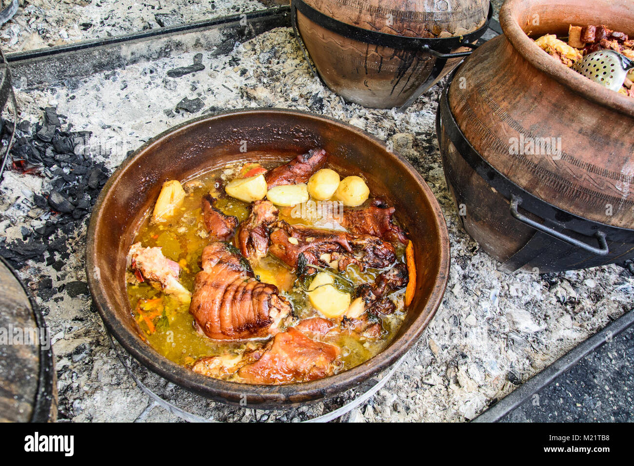Cooking a pork and a traditional earthen path in an open space Stock ...