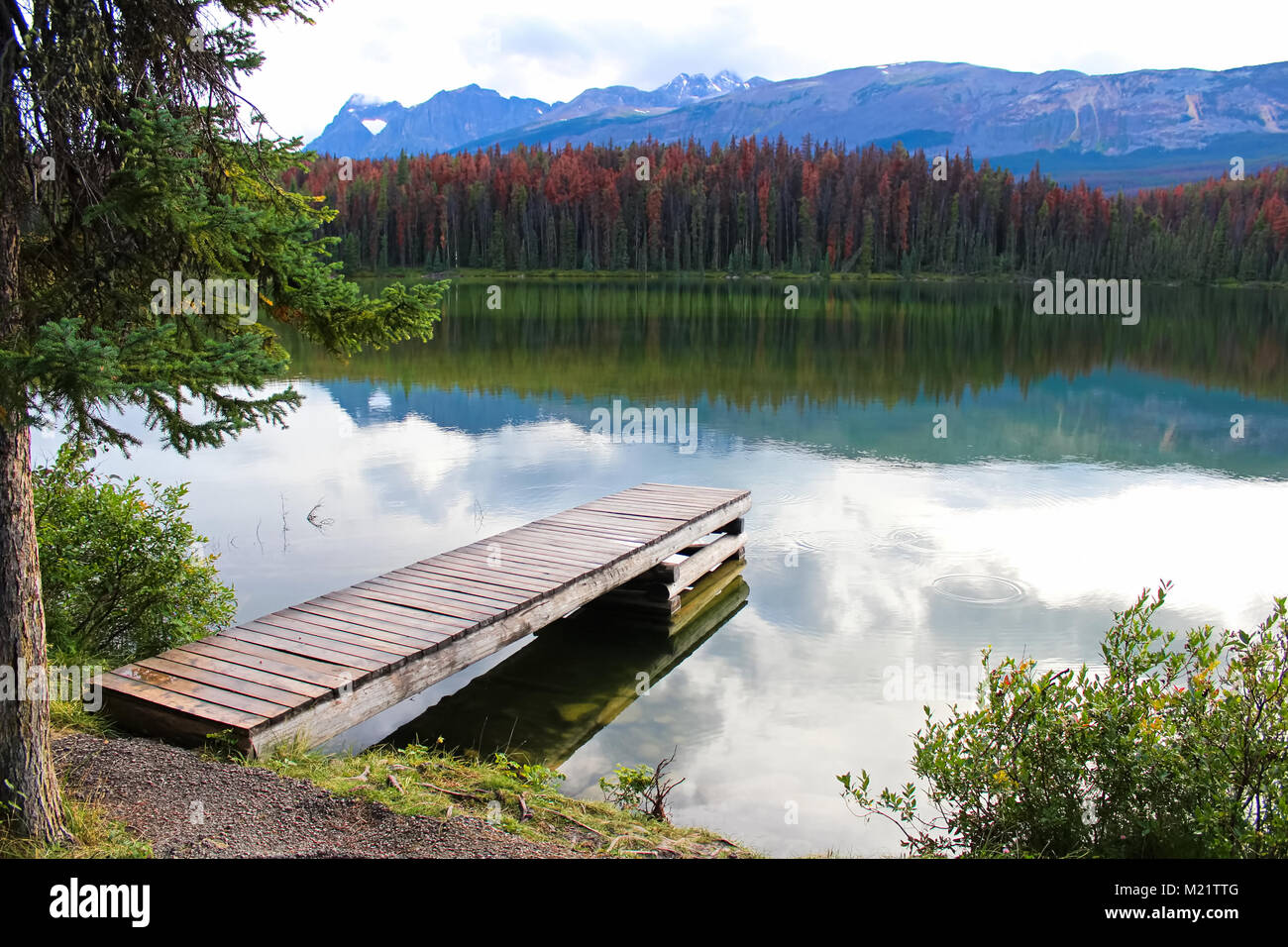 A dock beside a rocky mountain lake Stock Photo - Alamy