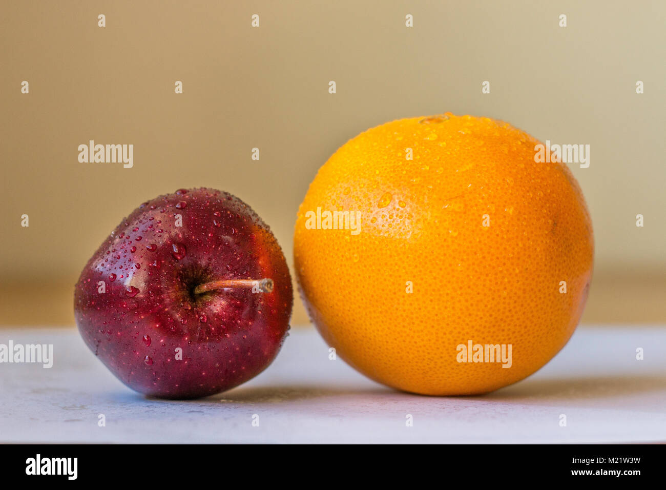 One Red Apple and One Orange together Stock Photo - Alamy