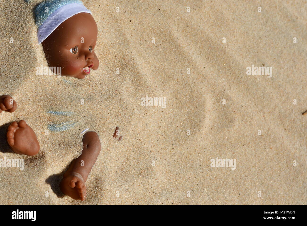 Boy dolls in the sand, dark skin toy dolls Stock Photo - Alamy