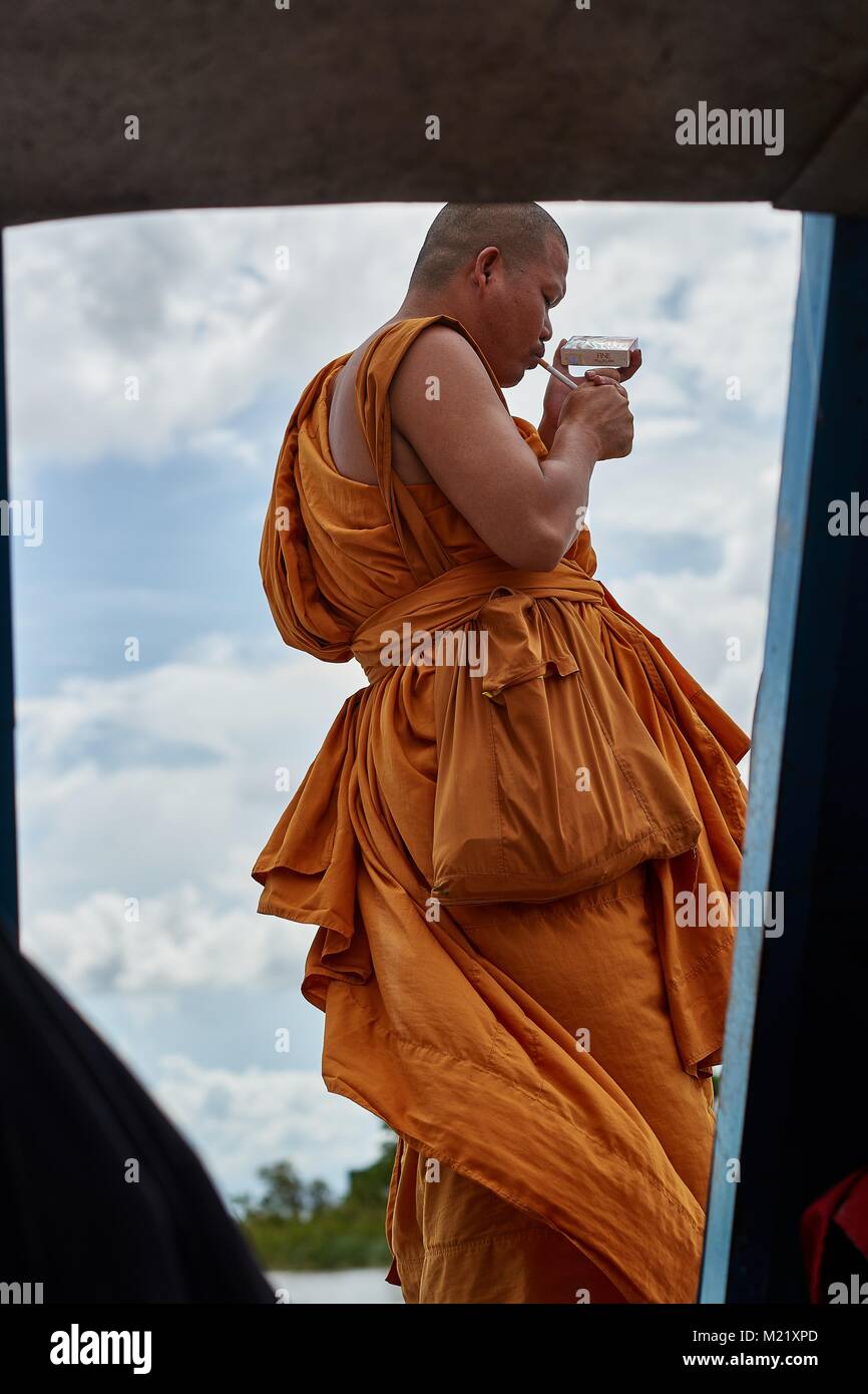 Monk smoking on a boat, Tonlé Sap, Cambodia Stock Photo - Alamy