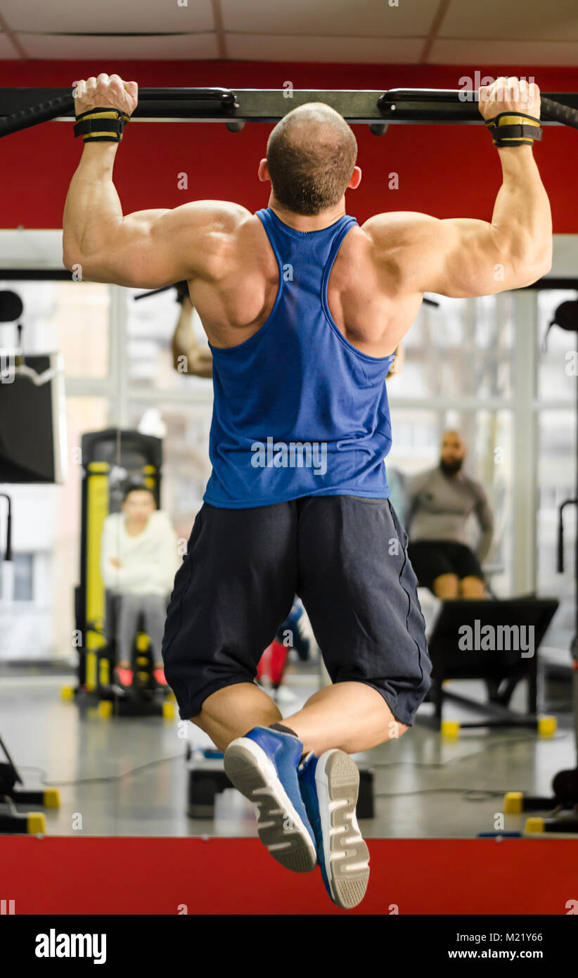 People in the gym watching as professional bodybuilder training, doing ...