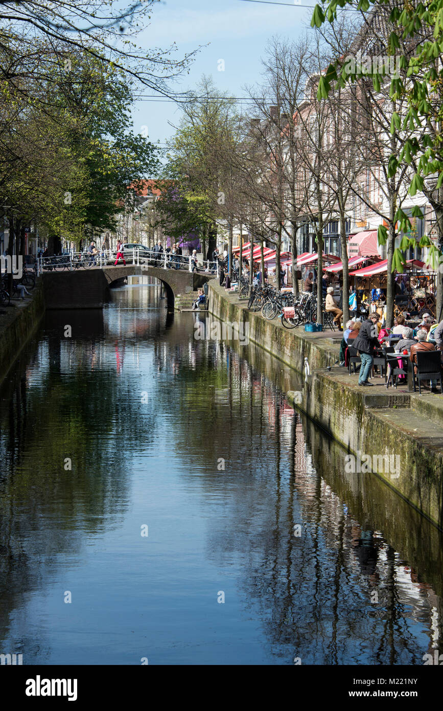 Outdoor restaurants line the banks of the Delftse Schie waterway or ...