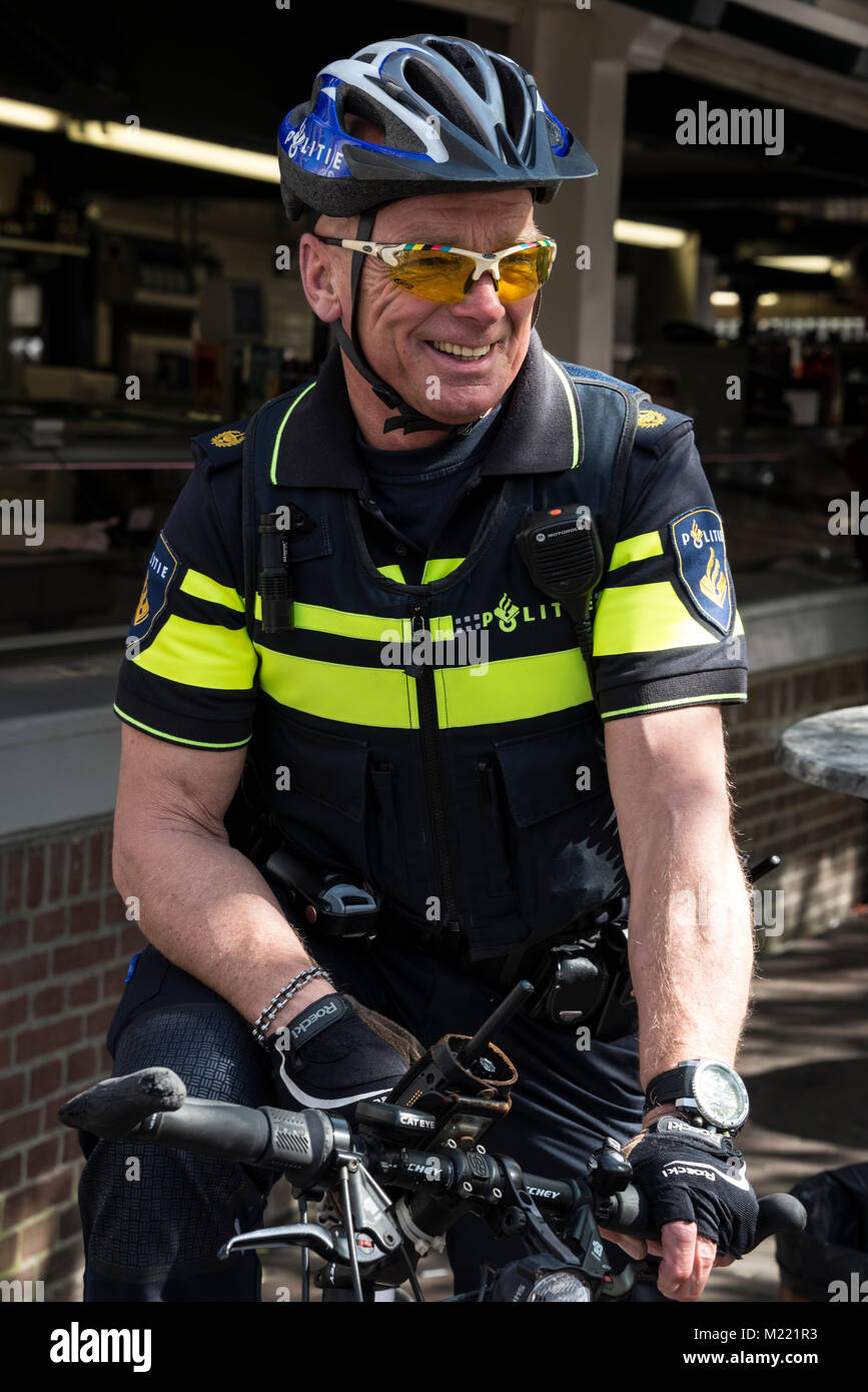 A Delft City policeman on his patrol wearing his required cycle helmet ...