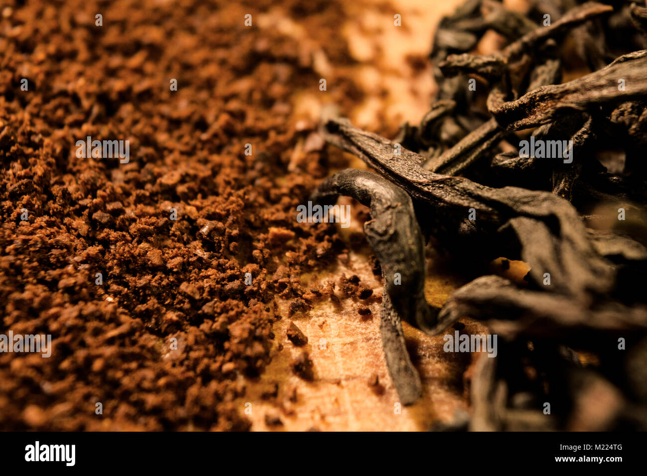 Tea vs coffee. Two small pile of tea leafs and ground coffee powder ...