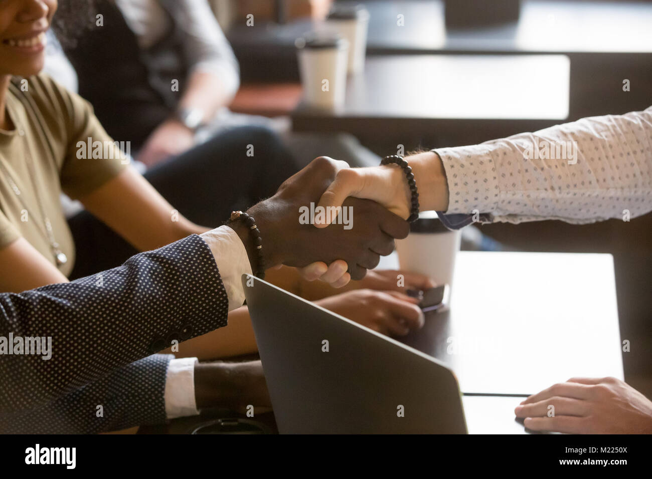 Multiracial men shaking hands in coffee house, close up view Stock ...
