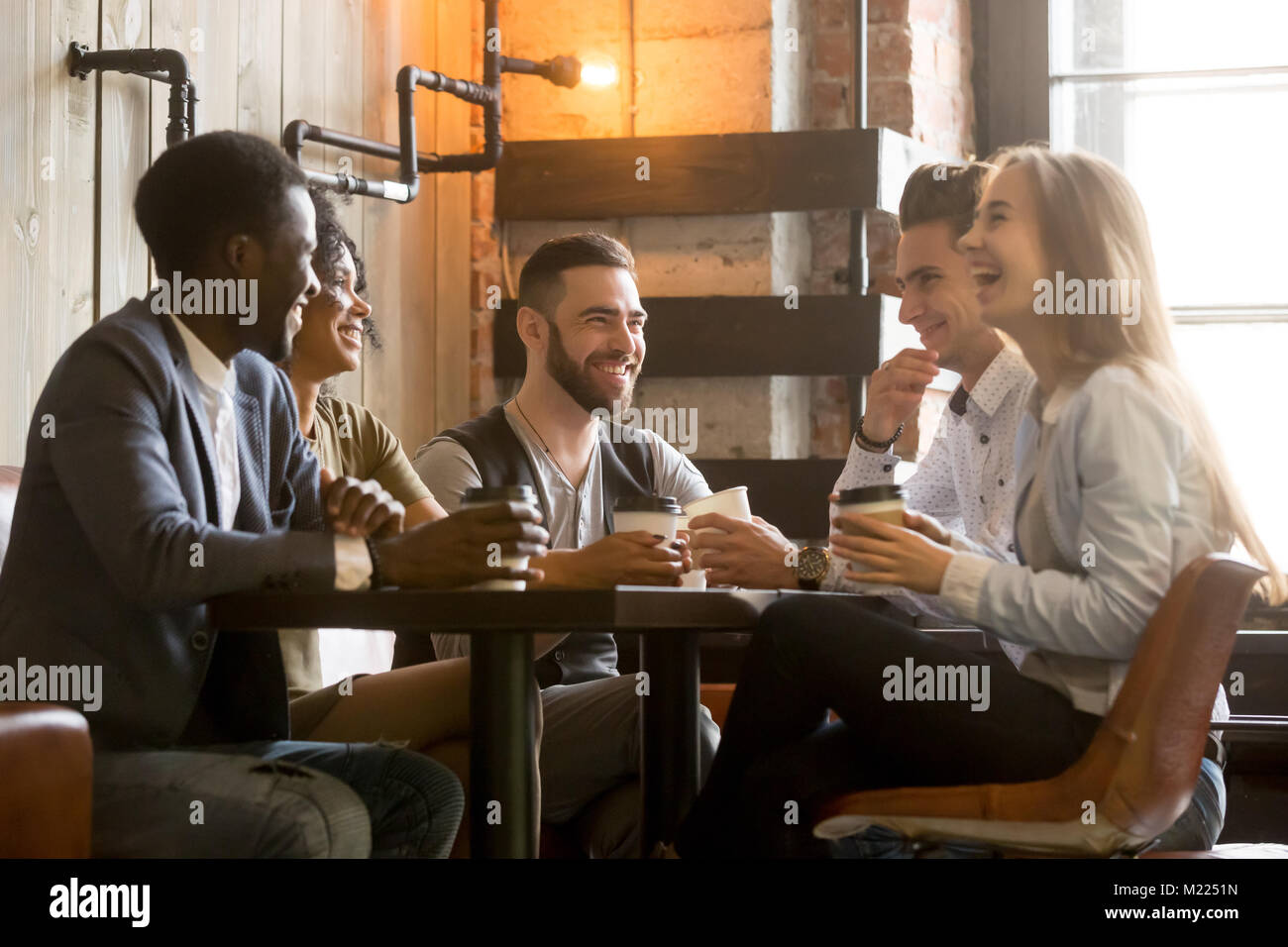 Multiracial young friends having fun laughing drinking coffee in Stock ...