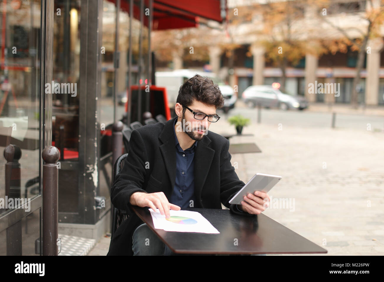 Statistician working with diagram and tablet at cafe table Stock Photo ...